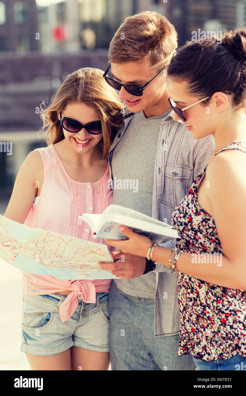 smiling friends with map and city guide outdoors Stock Photo - Alamy