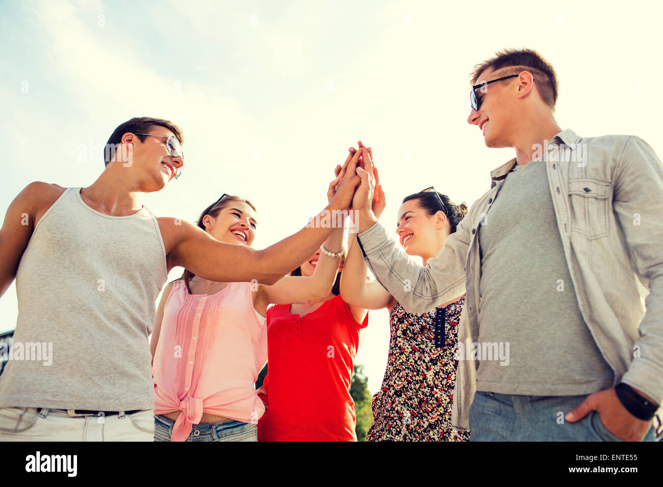 group of smiling friends making high five outdoors Stock Photo - Alamy