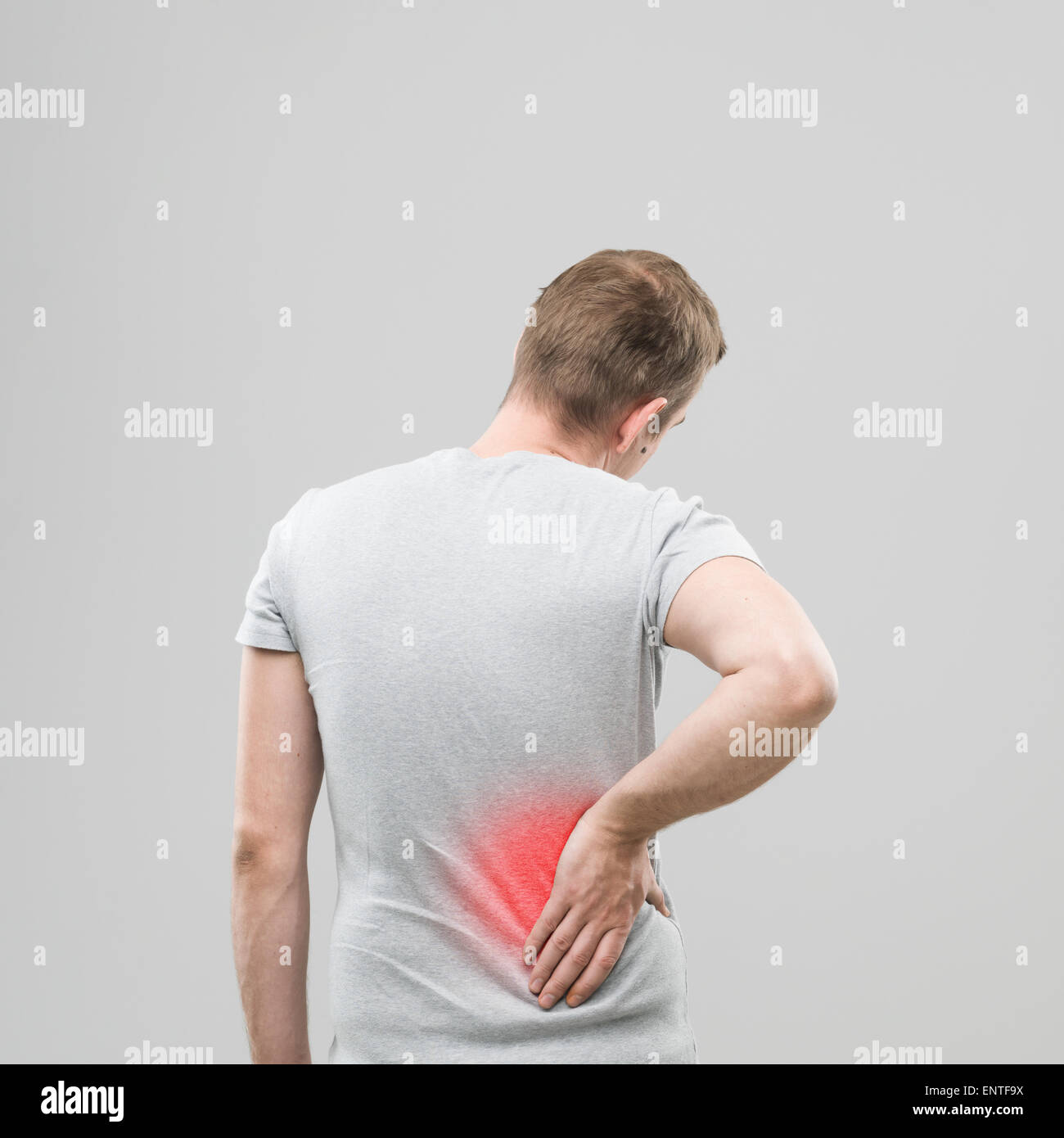 rear view of man experiencing back pain, with red spot marking the ...