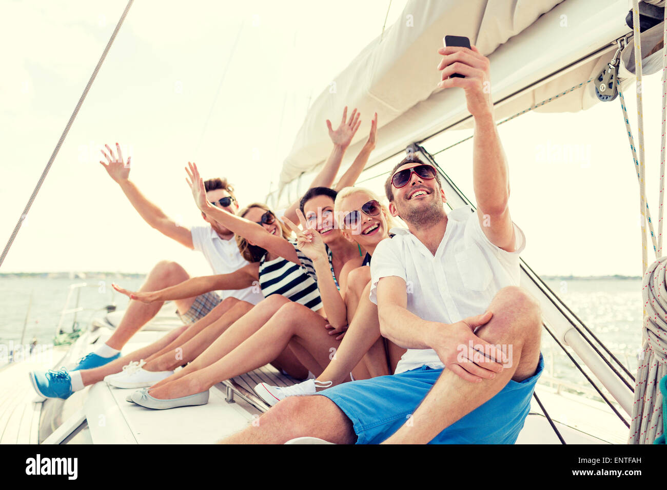 smiling friends sitting on yacht deck Stock Photo - Alamy