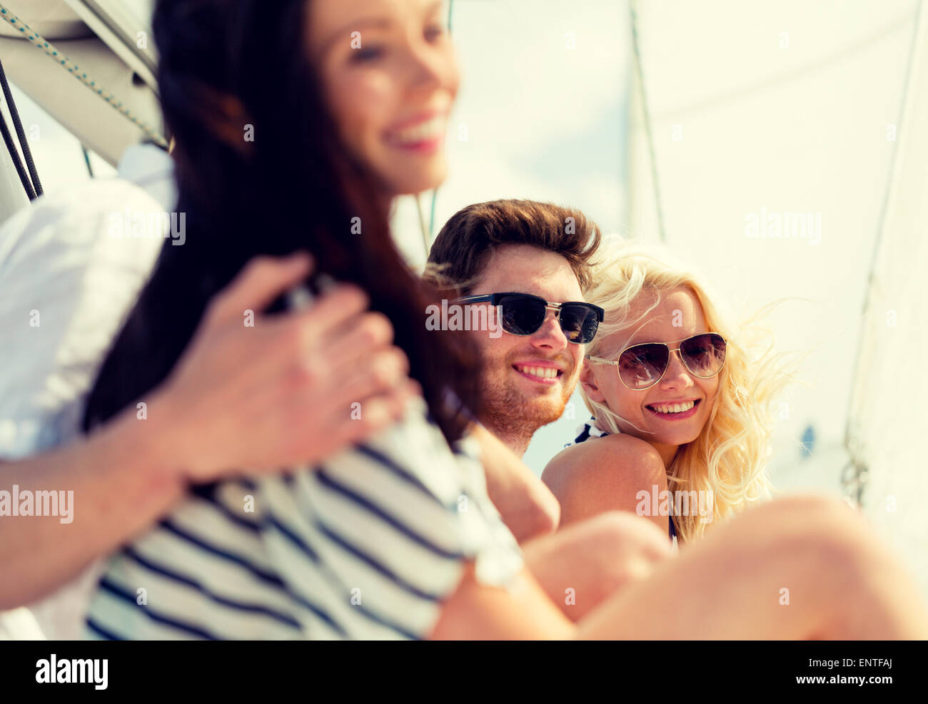 smiling friends sitting on yacht deck Stock Photo - Alamy