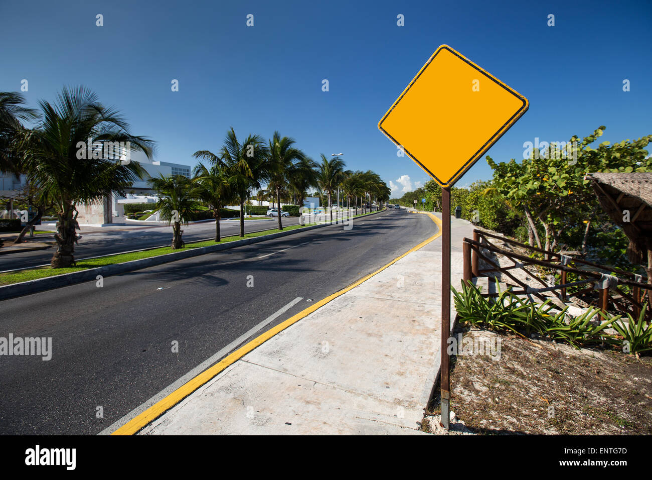 Empty yellow road sign. Tropical street Stock Photo - Alamy