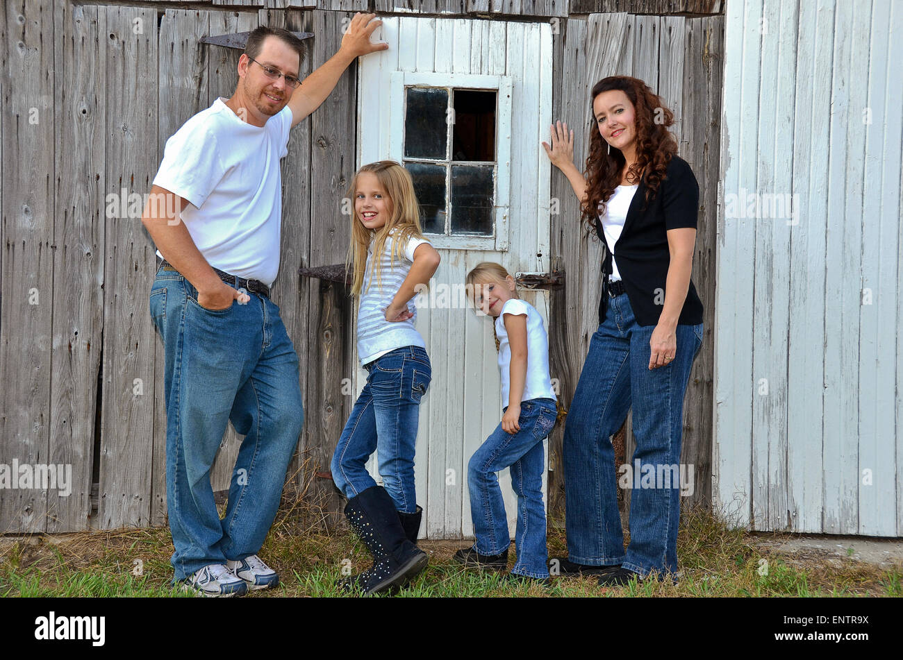 Happy young American family posing by an old barn Stock Photo - Alamy