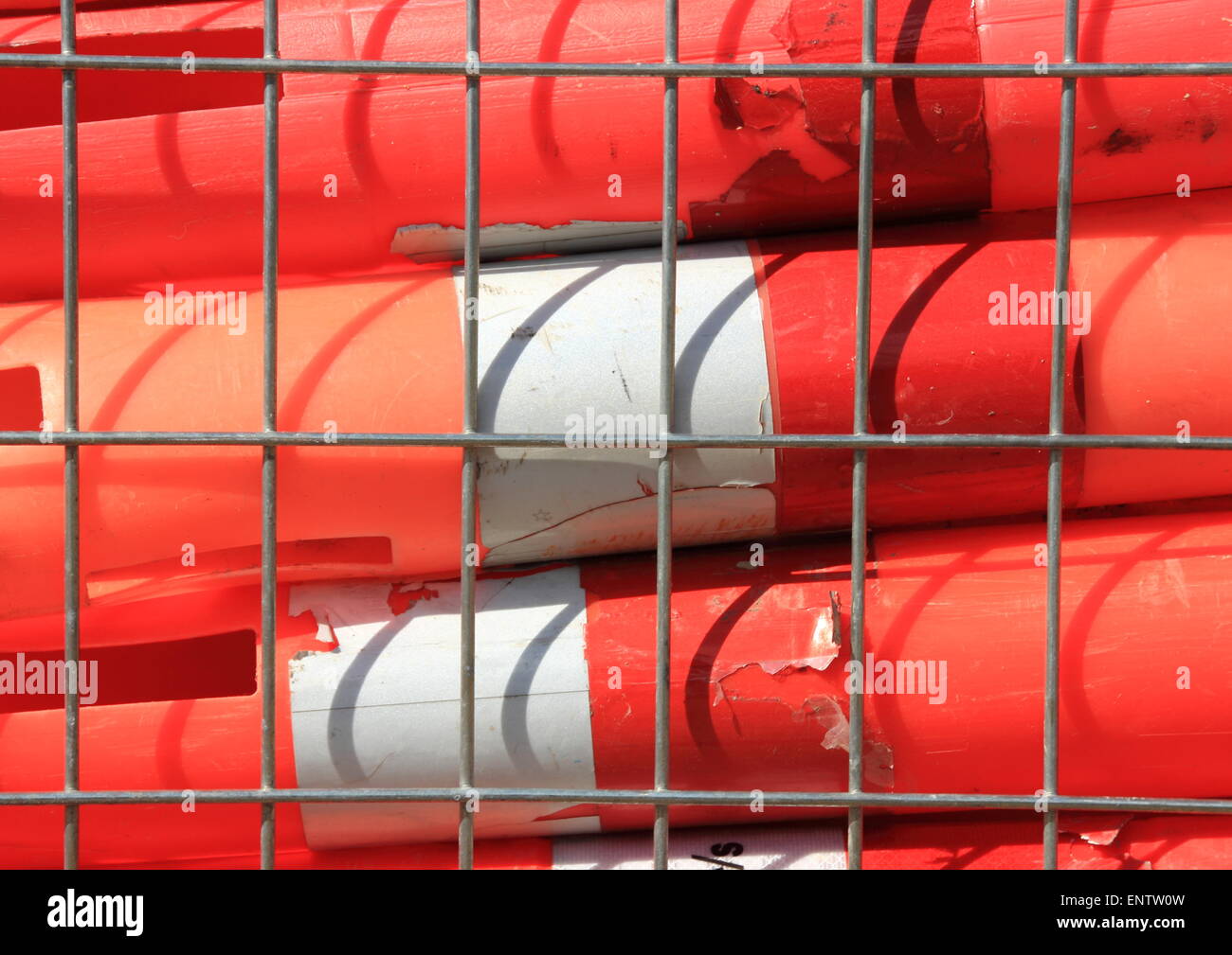 Orange warning tubes in metal grid Stock Photo - Alamy