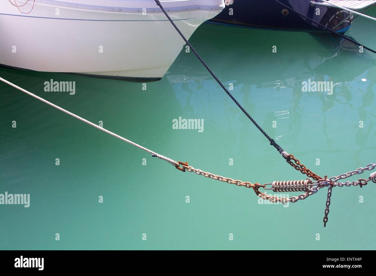 Detail of mooring rope, green water and white sailboat in marina Stock ...
