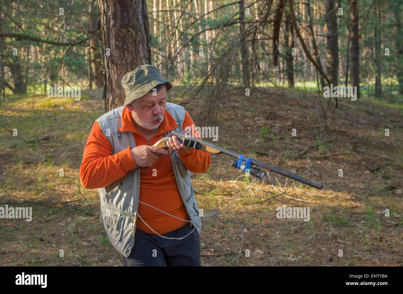 Outdoor portrait of senior hunter examining of hunting rifle barrel ...