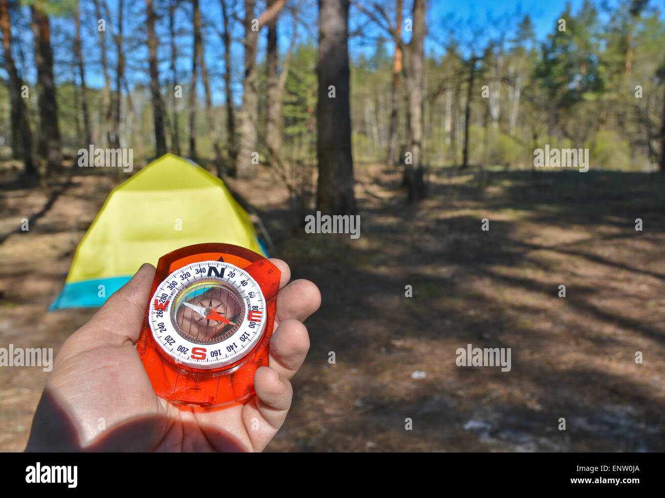 Compass and tourist tent. The magnetic compass in the hand against the ...