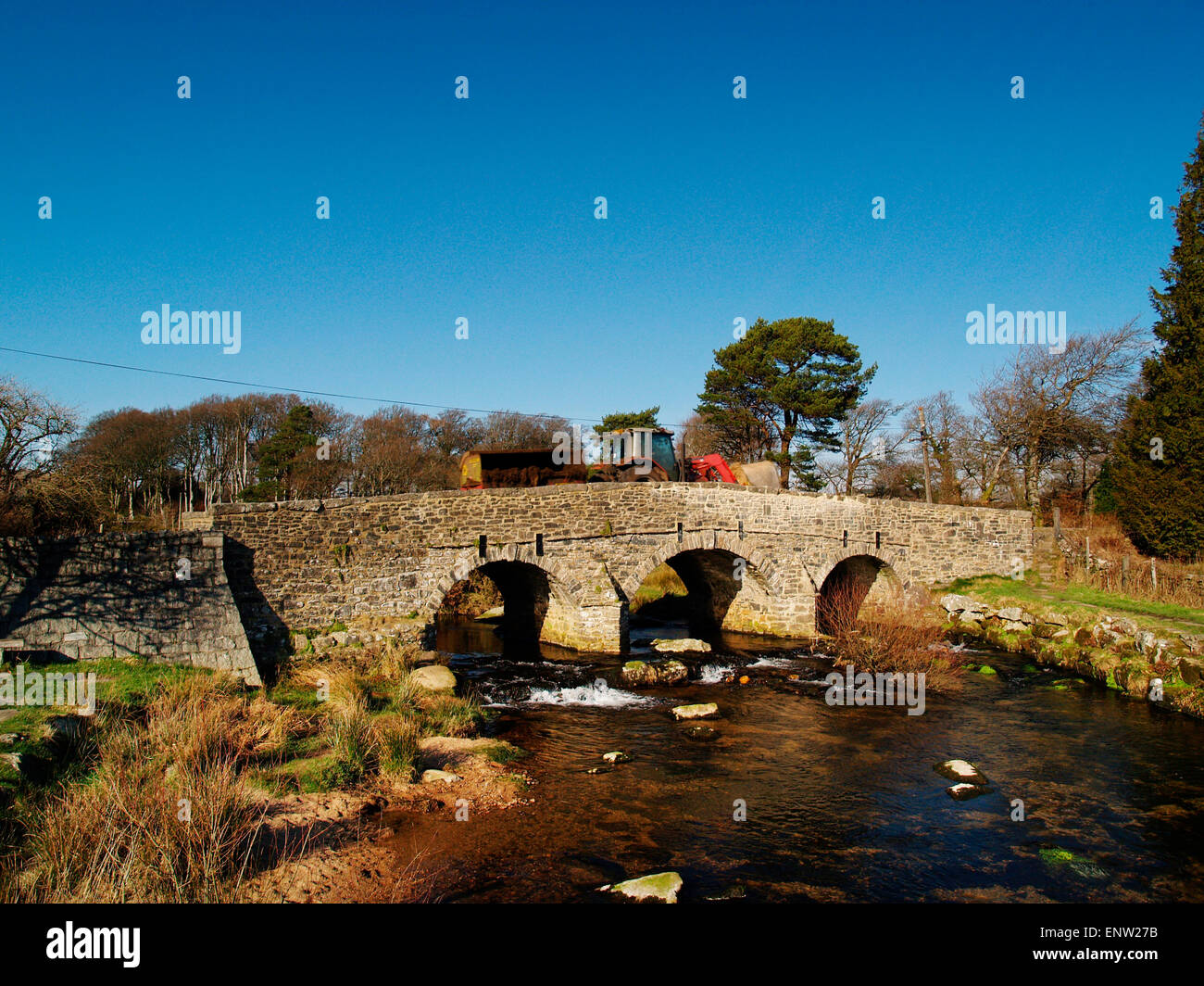 Tractor on a granite bridge crossing over East Dart River on Dartmoor ...