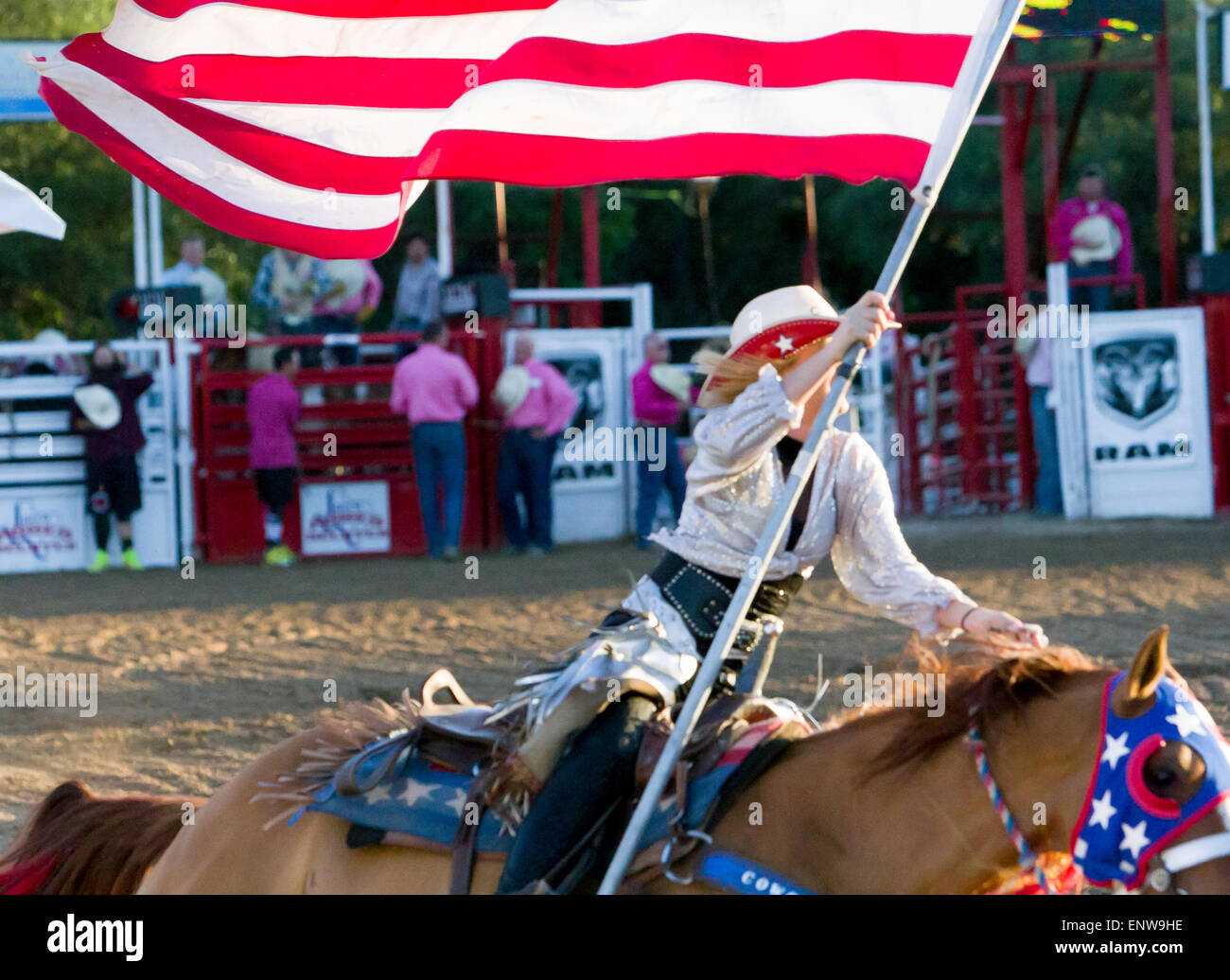 A cowgirl bears the American flag in the opening ceremony at the ...