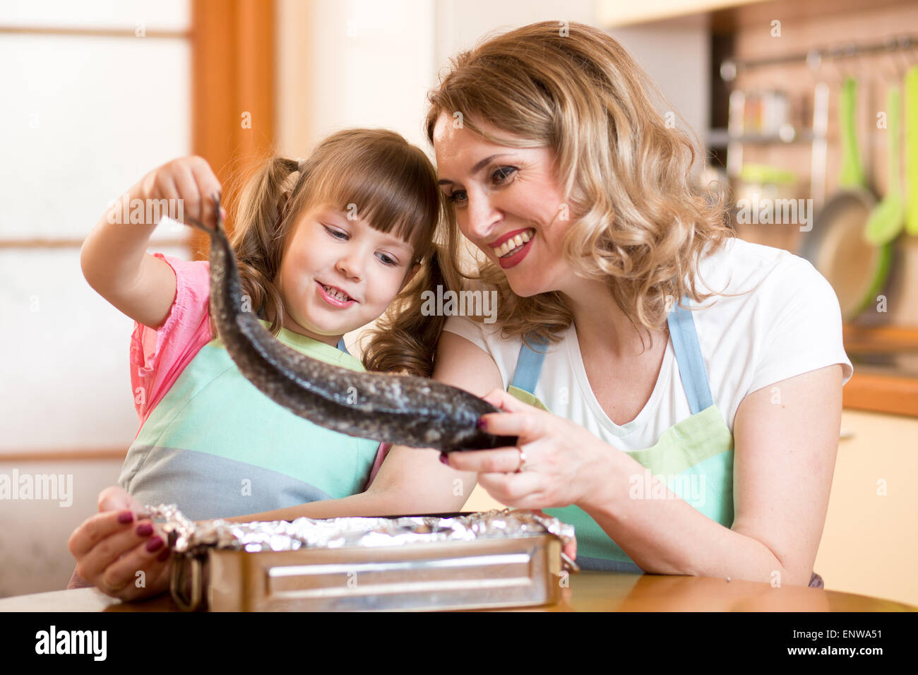 child girl with mother cooking fish in domestic kitchen Stock Photo - Alamy