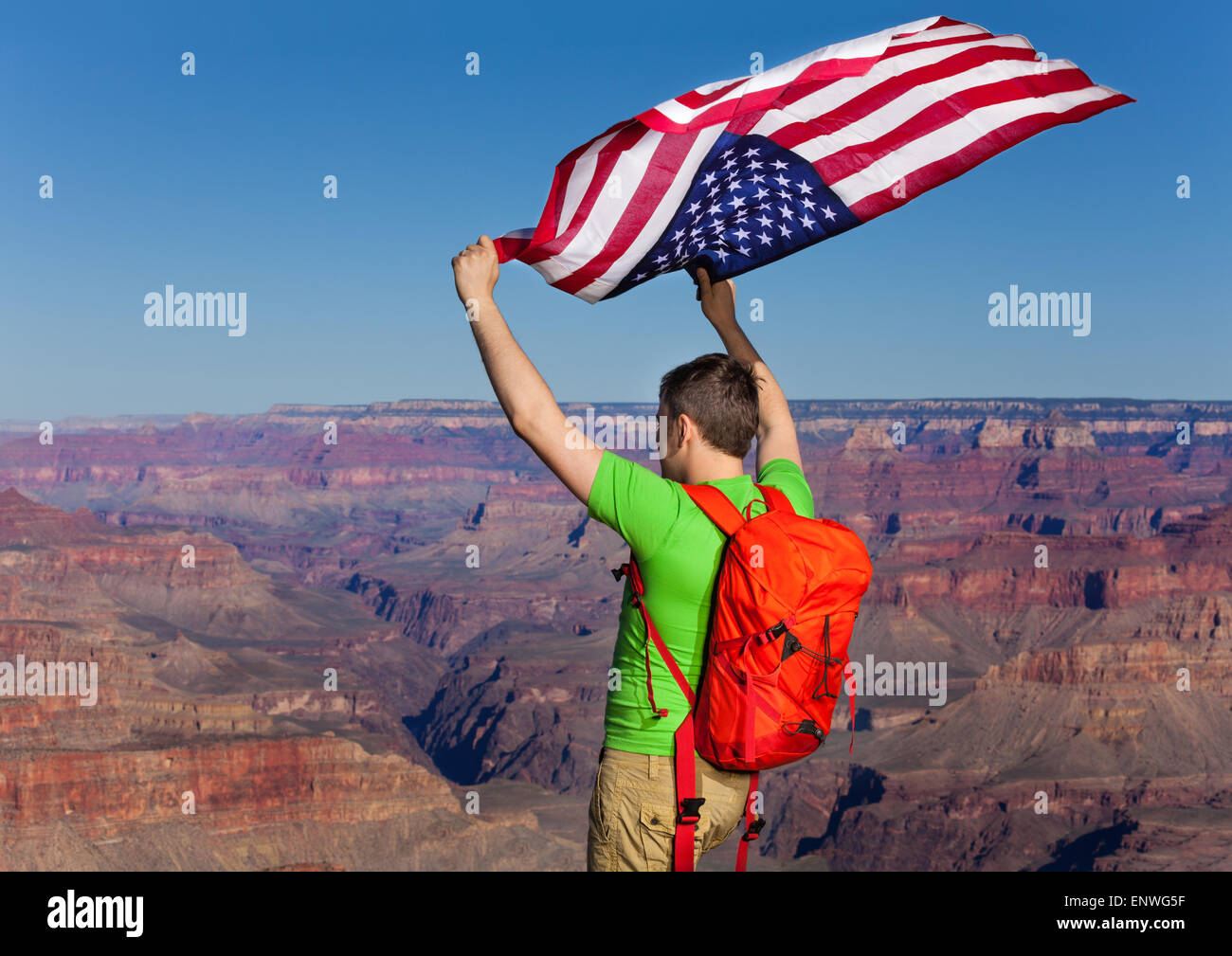 Back of a man with rucksack holding American flag Stock Photo - Alamy