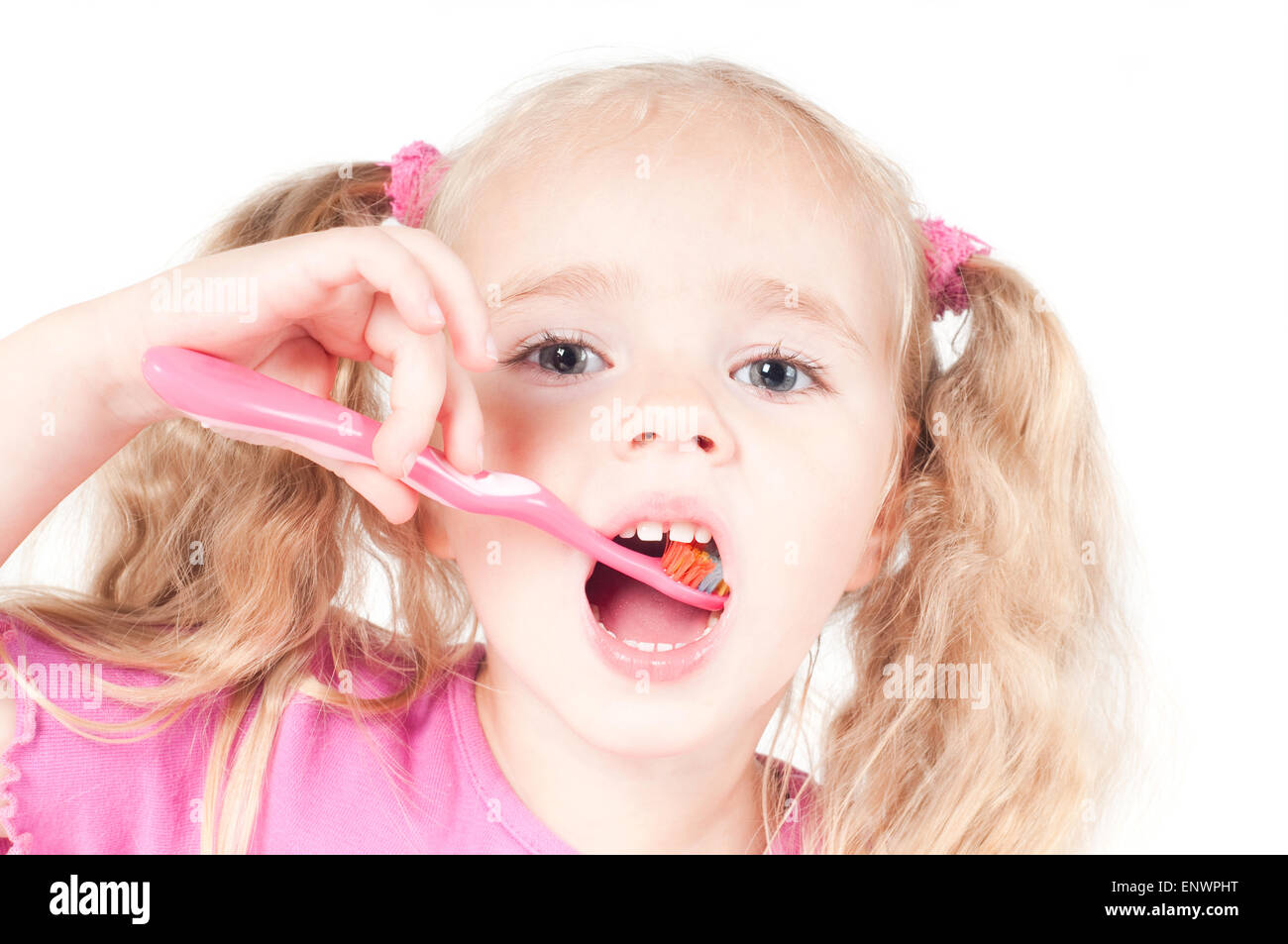 Little cute girl in studio brushing teeth Stock Photo - Alamy