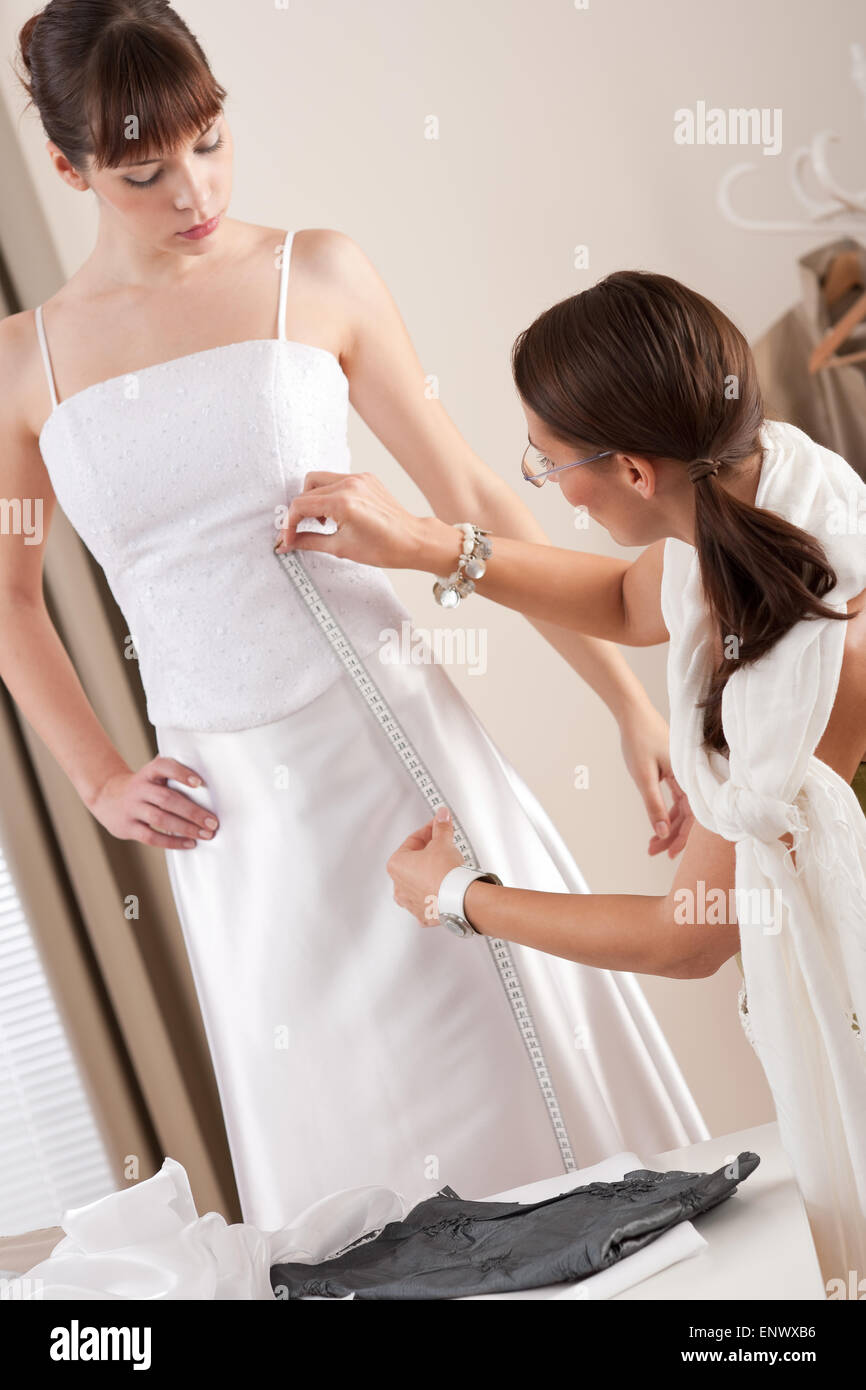 Fashion model fitting white wedding dress by designer Stock Photo - Alamy