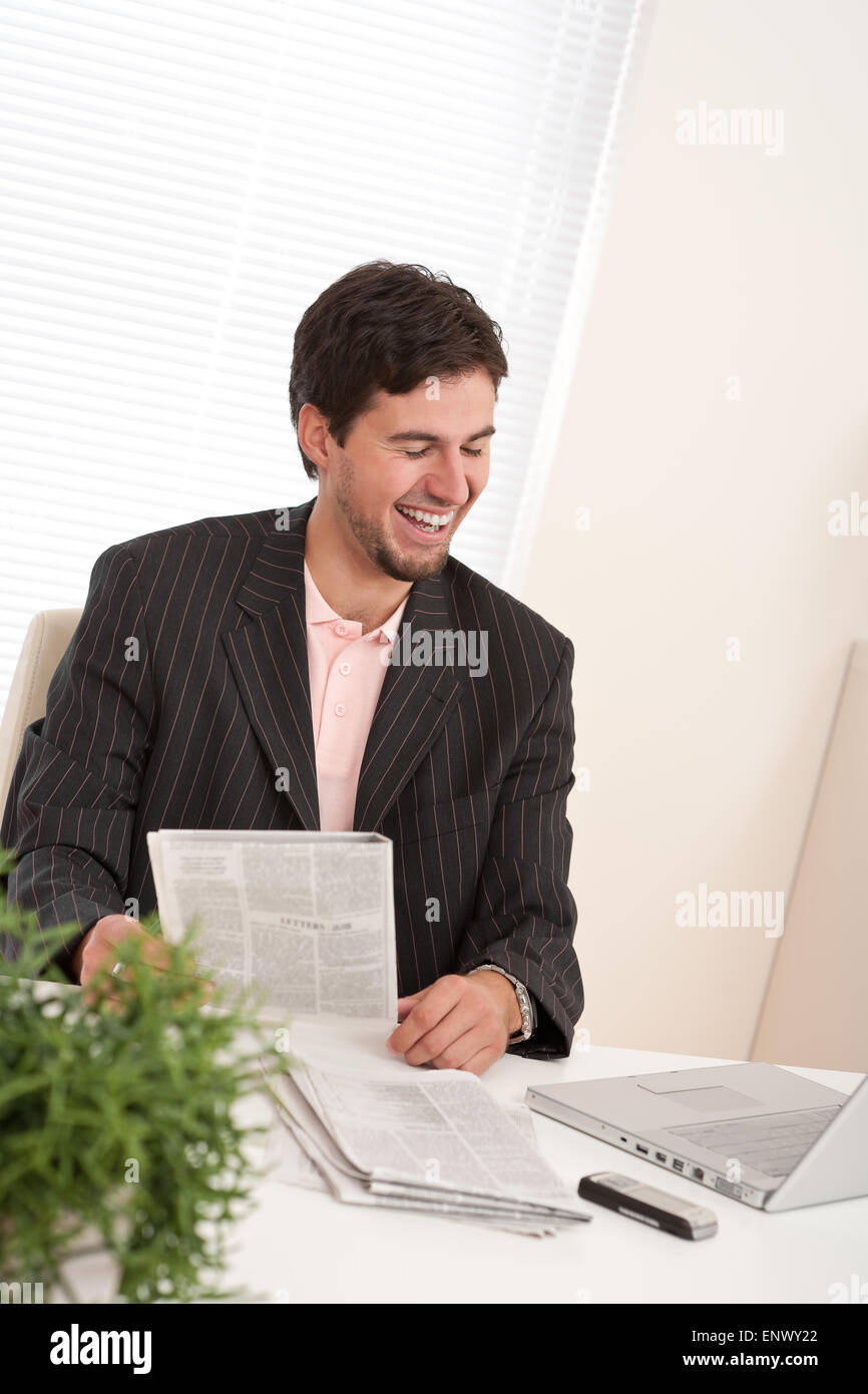 Successful modern businessman with laptop and newspaper Stock Photo - Alamy