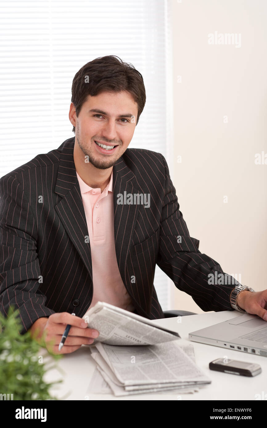 Successful modern businessman with laptop and newspaper Stock Photo - Alamy