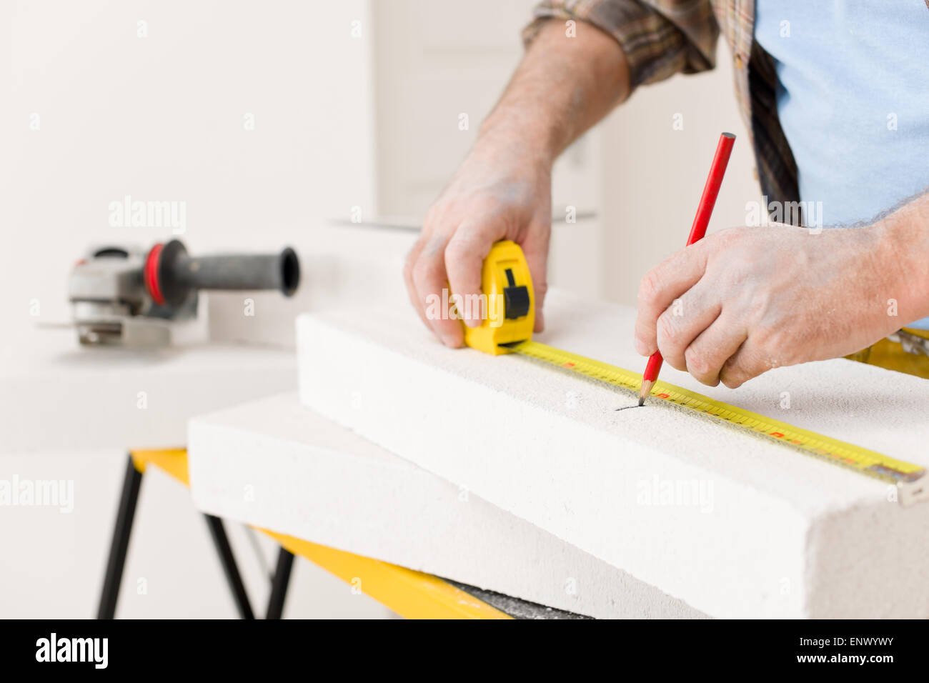 Home improvement - handyman measure porous brick Stock Photo - Alamy