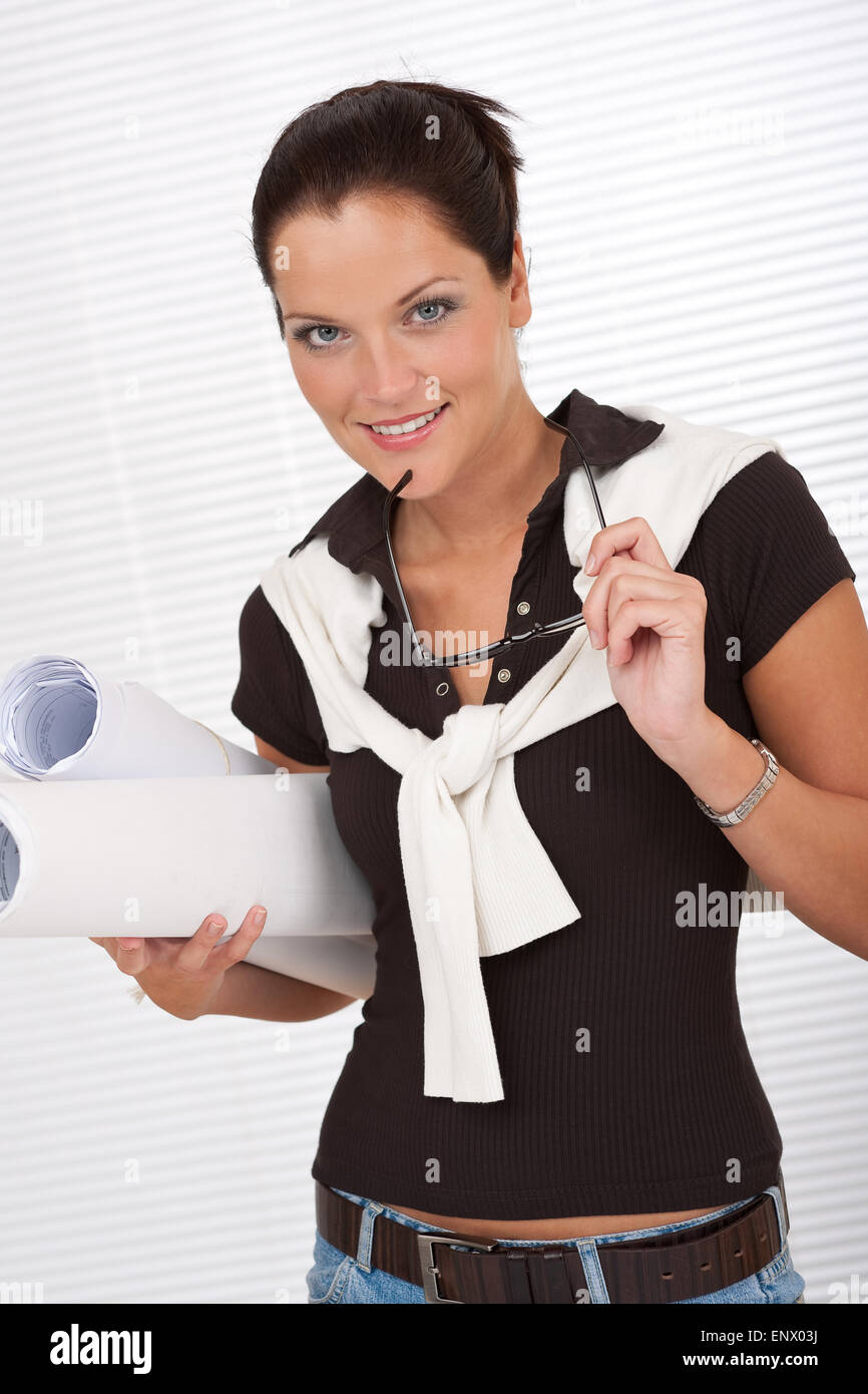 Smiling female architect holding plans and glasses Stock Photo - Alamy Smiling female architect holding plans and glasses Stock Photo - Alamy