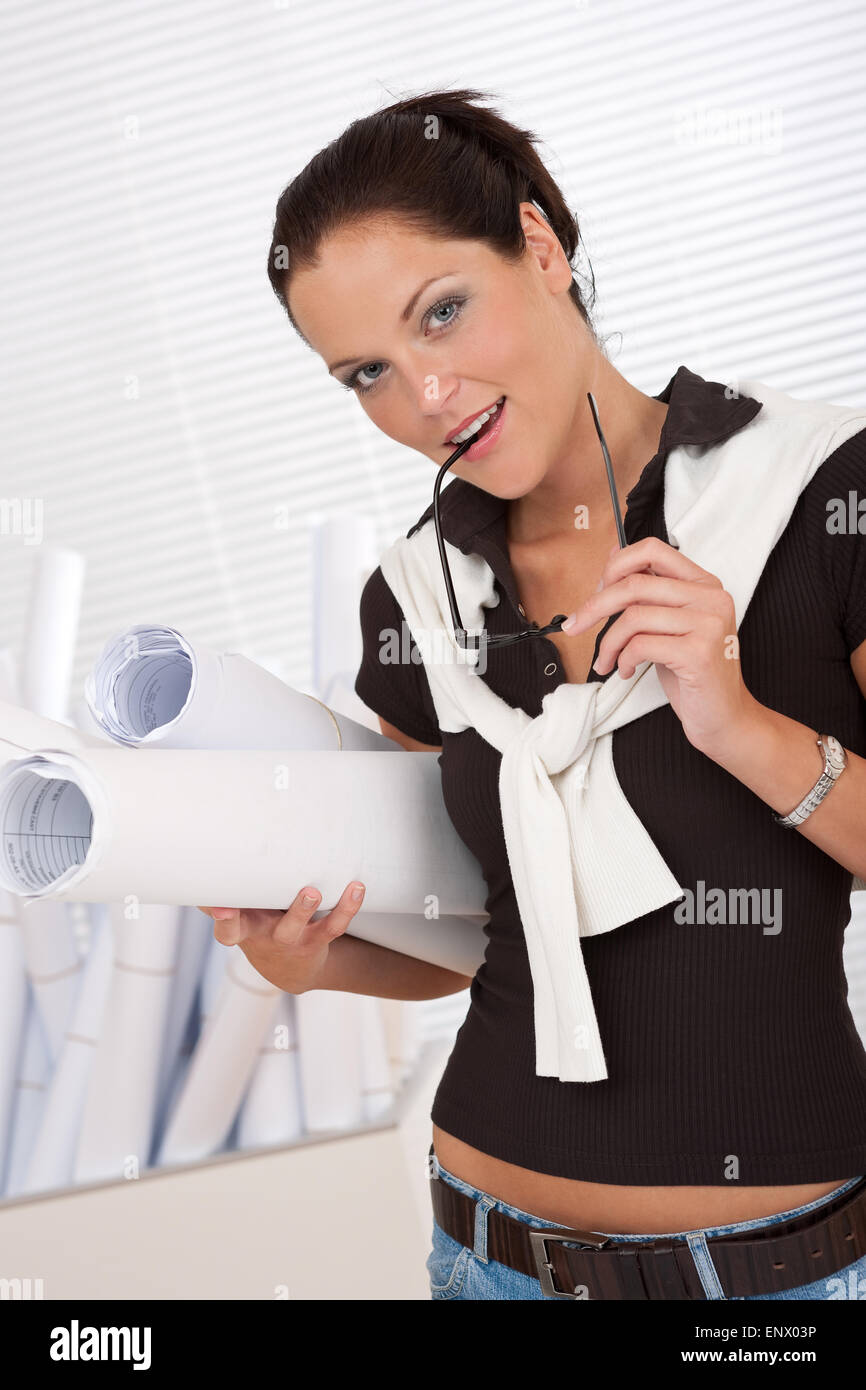 Smiling female architect holding plans and glasses Stock Photo - Alamy Smiling female architect holding plans and glasses Stock Photo - Alamy
