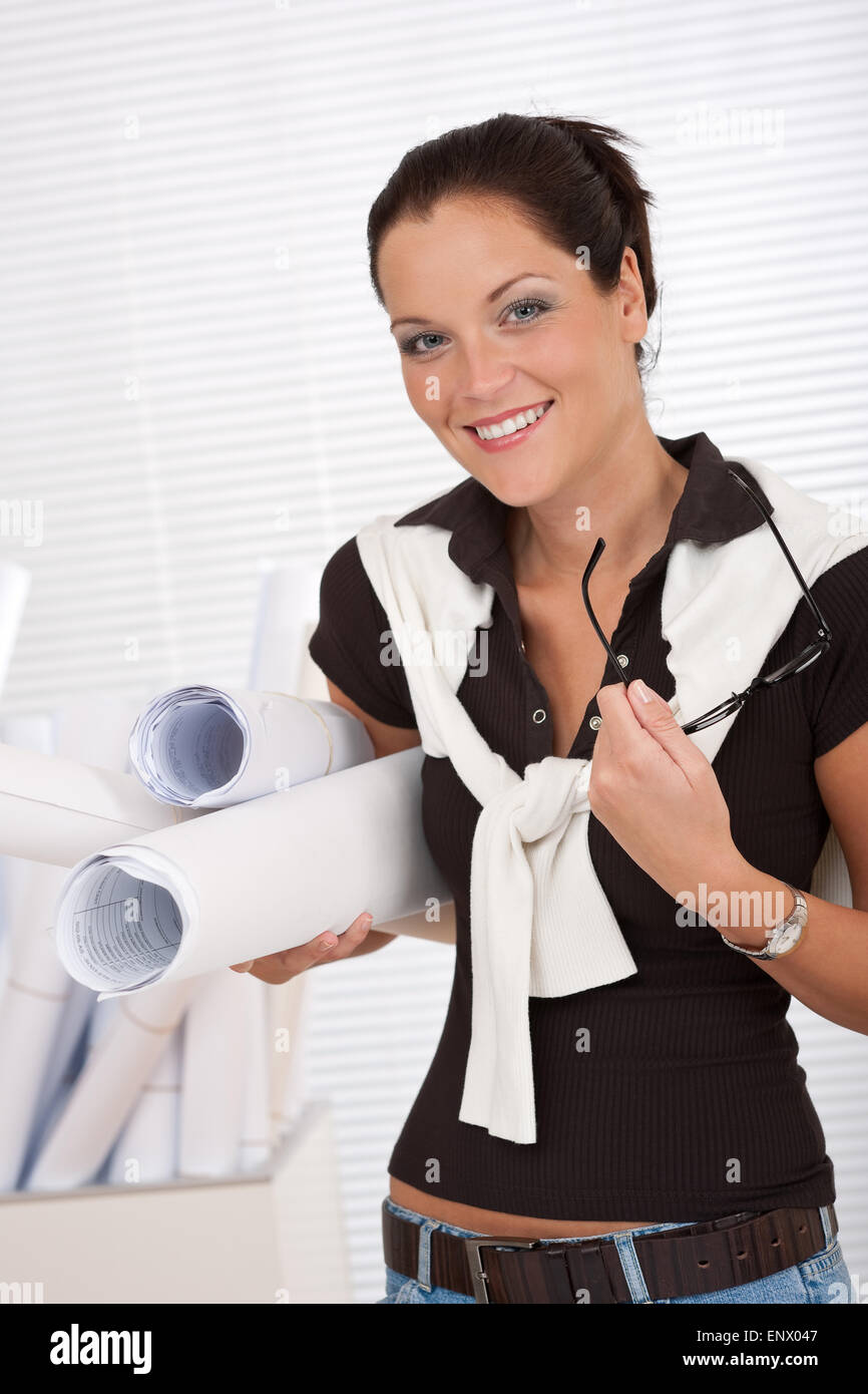 Smiling female architect holding plans and glasses Stock Photo - Alamy Smiling female architect holding plans and glasses Stock Photo - Alamy