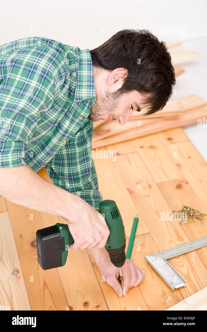 Home improvement - handyman installing wooden floor Stock Photo - Alamy