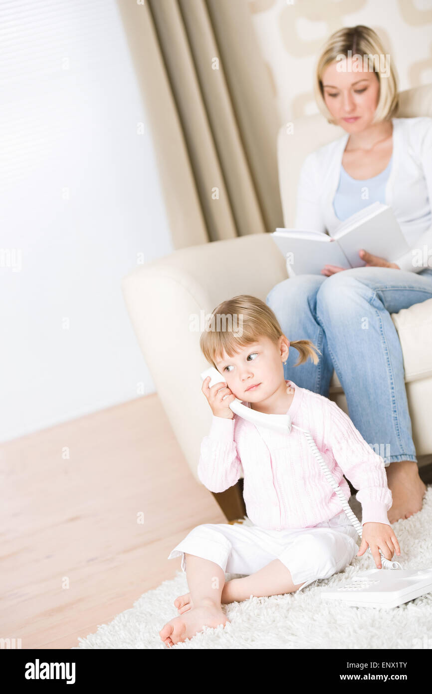 Mother and child - on the phone in living room Stock Photo - Alamy
