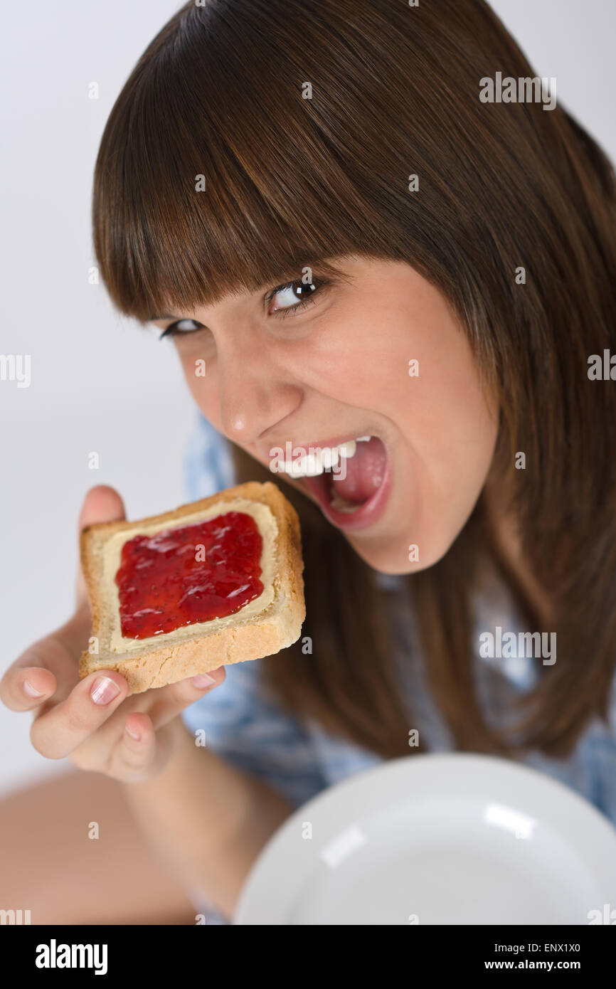 Happy teenager in pajamas eating healthy toast Stock Photo - Alamy