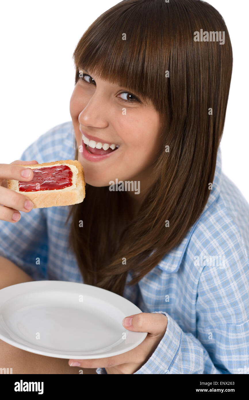 Happy teenager in pajamas eating healthy toast Stock Photo - Alamy