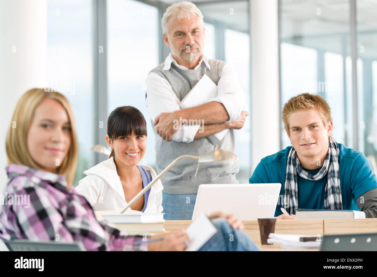 High school - three students with mature professor Stock Photo - Alamy