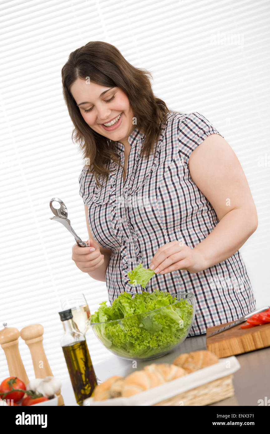Cook - Plus size happy woman preparing salad in kitchen Stock Photo - Alamy