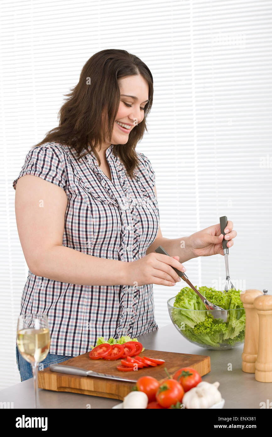Cook - Plus size happy woman preparing salad Stock Photo - Alamy