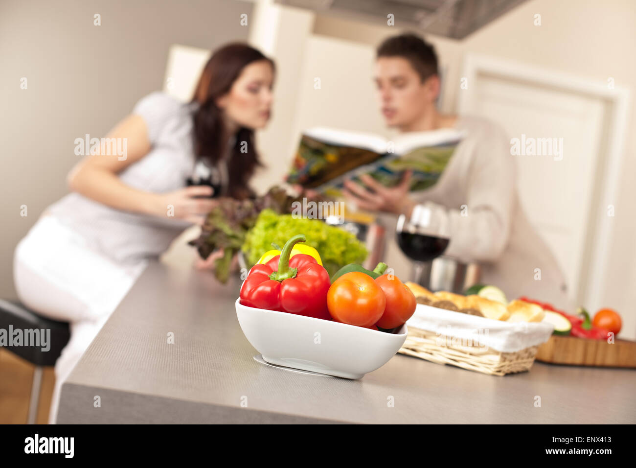 Couple in kitchen choosing recipe from cookbook Stock Photo - Alamy