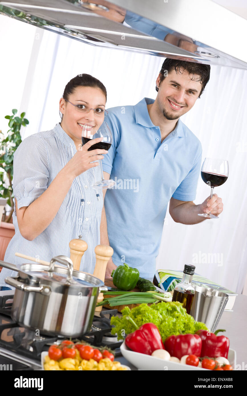 Smiling couple drink red wine cooking in kitchen Stock Photo - Alamy
