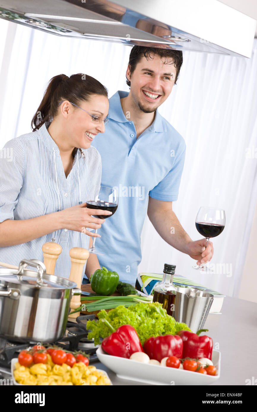 Smiling couple drink red wine cooking in kitchen Stock Photo - Alamy