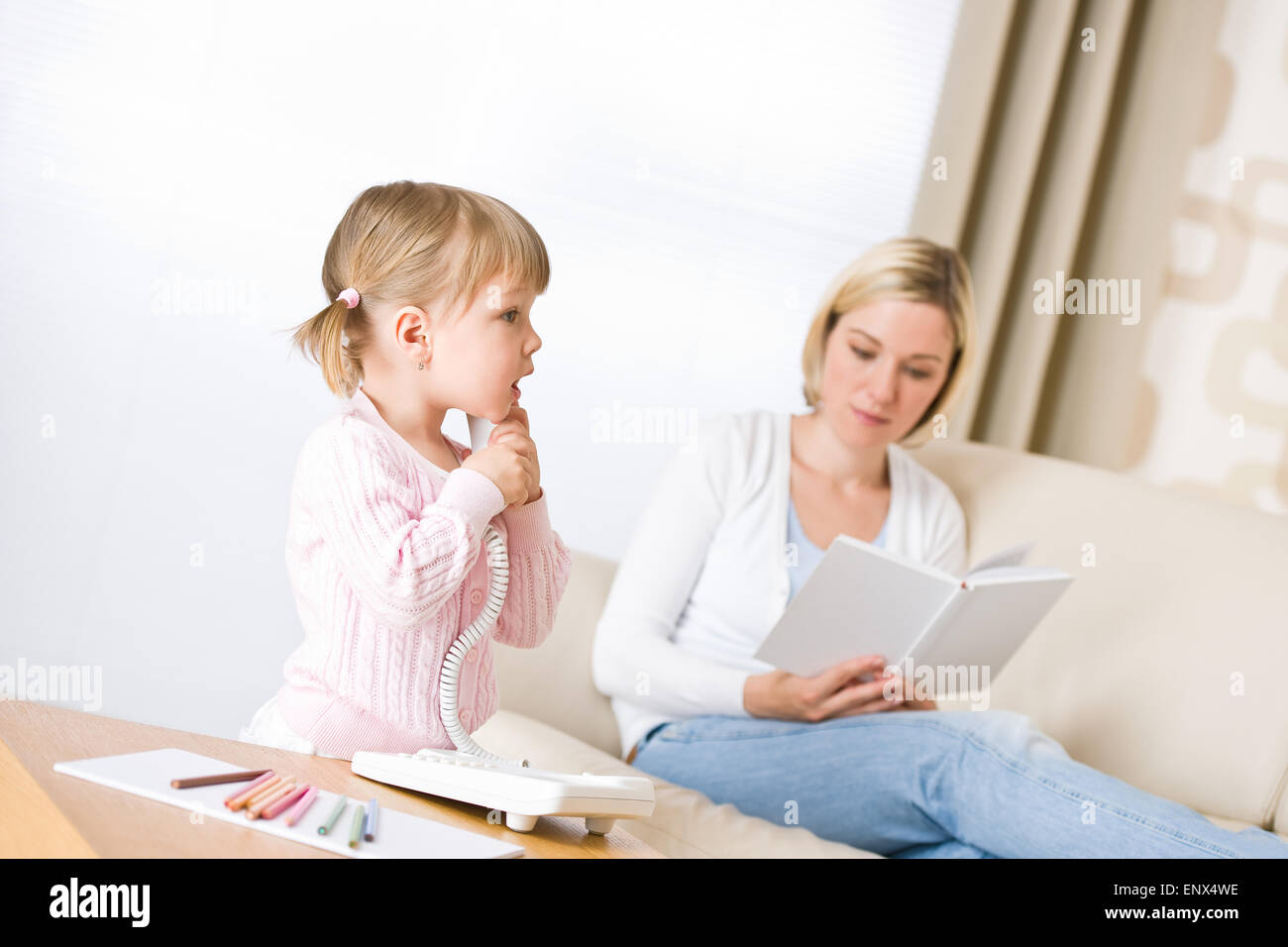 Mother and child - on the phone in living room Stock Photo - Alamy