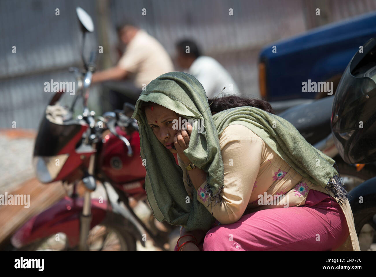 Kathmandu, Kathmandu. 12th May, 2015. A woman stays in the street after ...