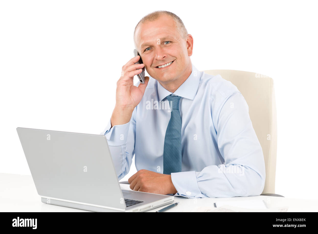 Smiling businessman sitting in office behind desk Stock Photo - Alamy