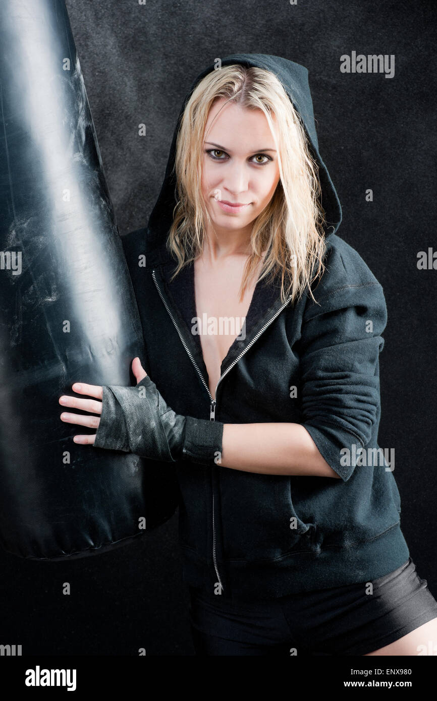 Boxing training woman in black hold punching bag Stock Photo - Alamy