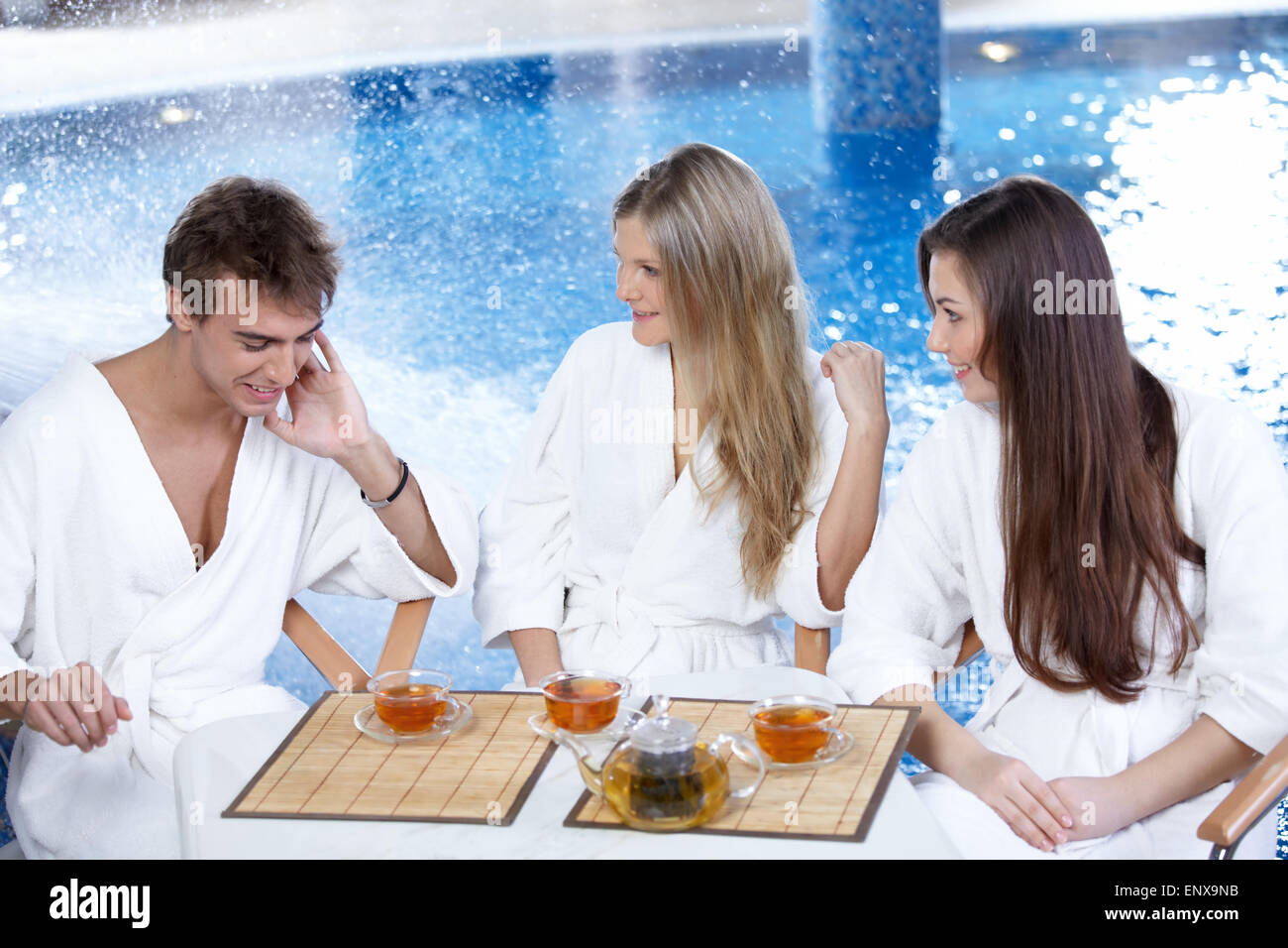 Friends communicate over a cup of tea against pool Stock Photo - Alamy