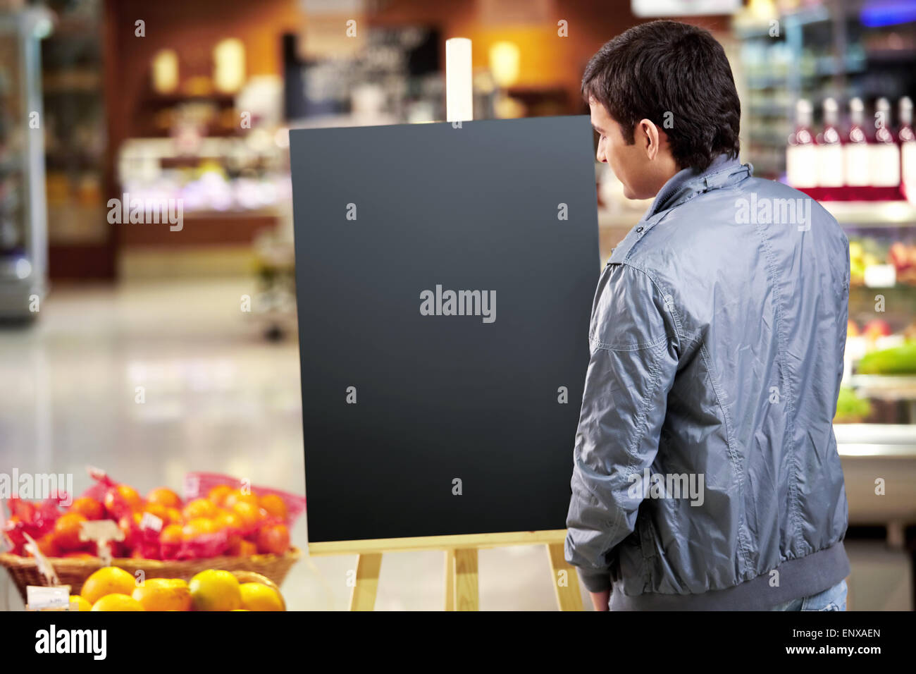 The young man looks at an empty board in shop Stock Photo - Alamy
