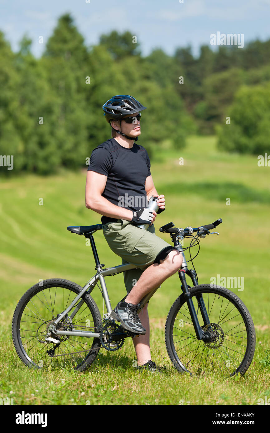 Sportive man mountain biking relax sunny meadows Stock Photo - Alamy
