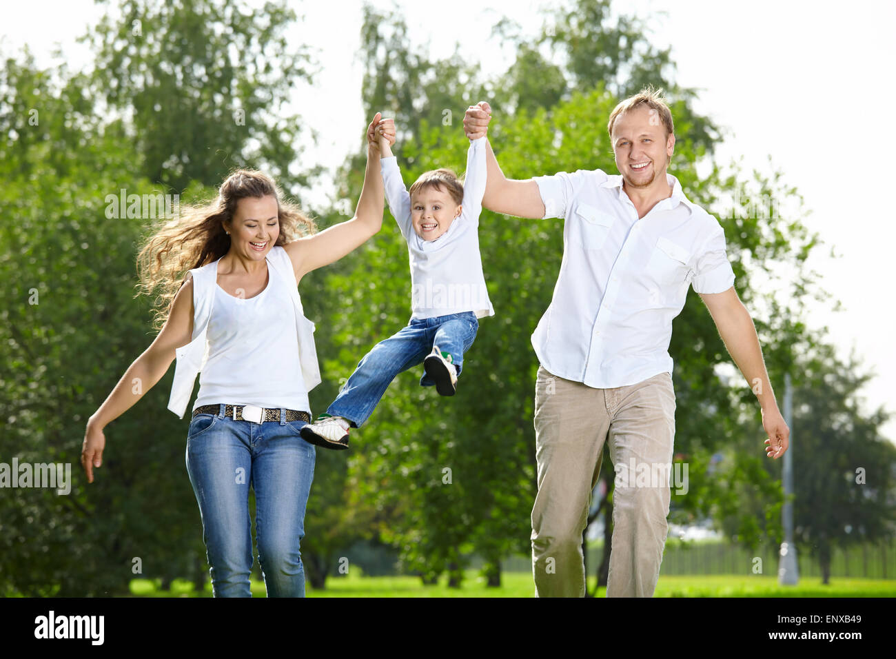 Parents with the small son frolic on the nature Stock Photo - Alamy