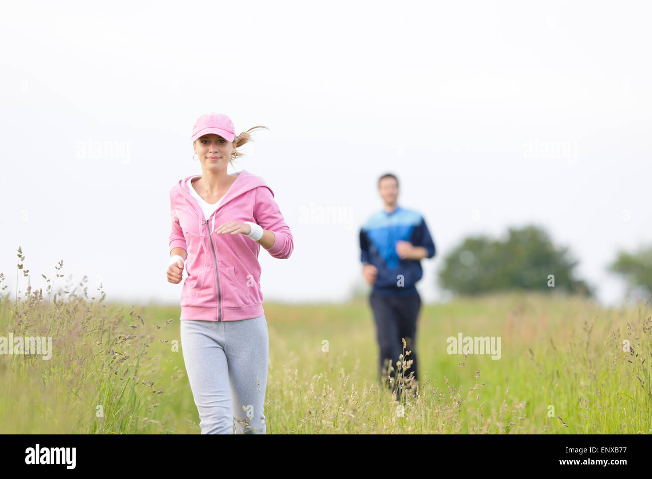 Jogging sportive young couple running meadow field Stock Photo - Alamy