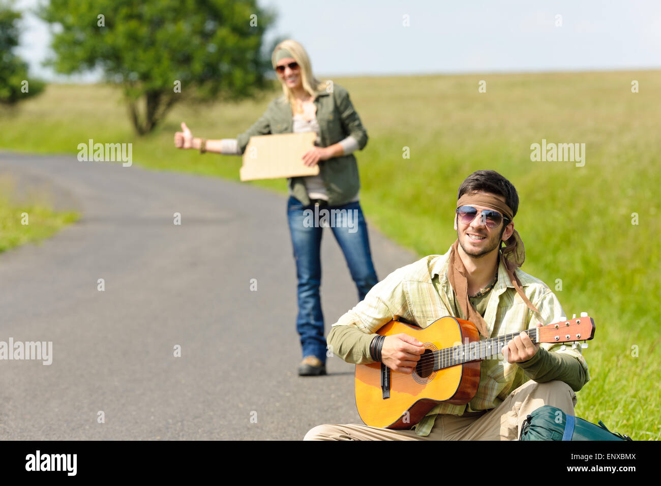 Hitch-hiking young couple backpack asphalt road Stock Photo - Alamy