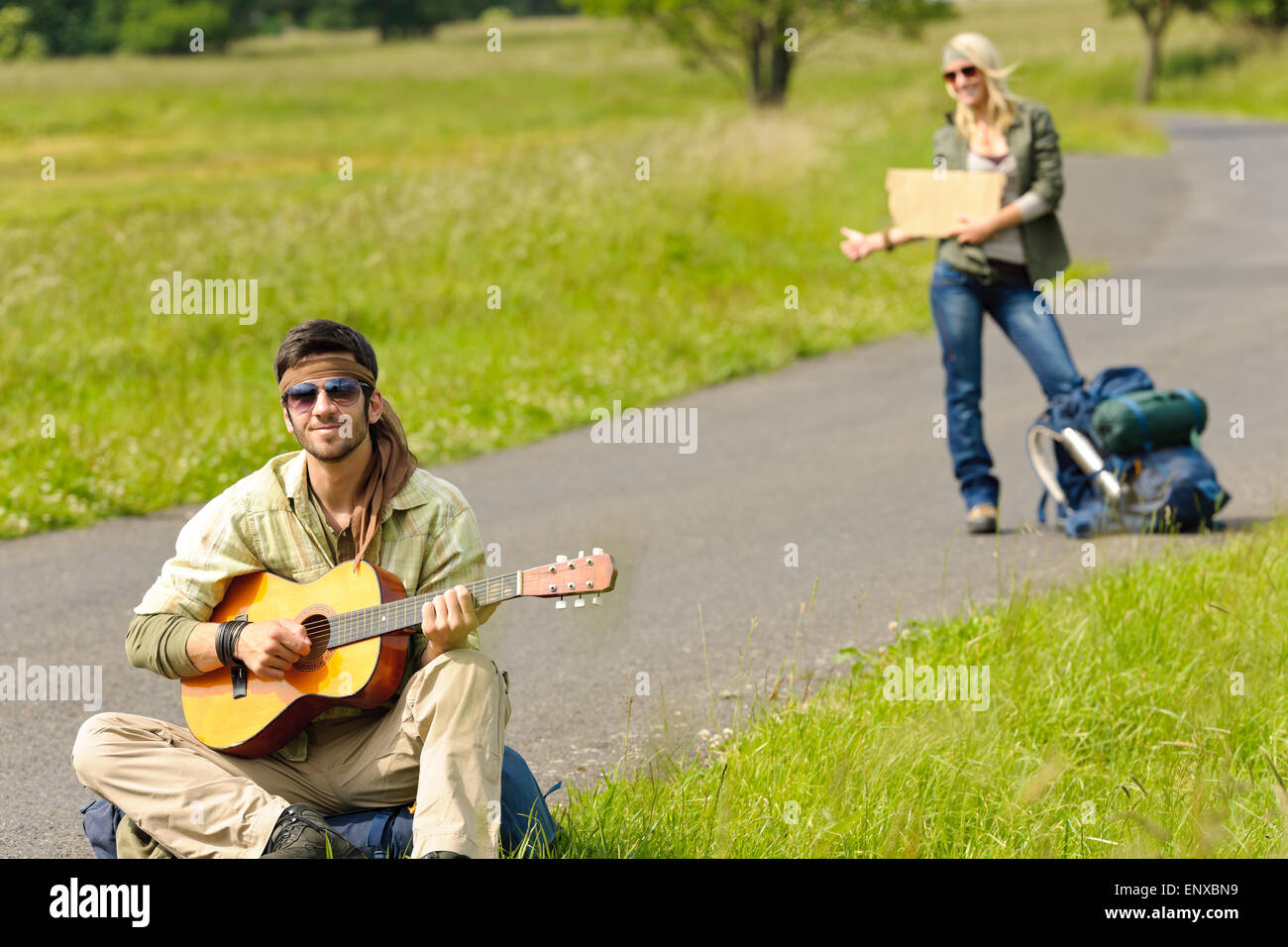 Hitch-hiking young couple backpack asphalt road Stock Photo - Alamy