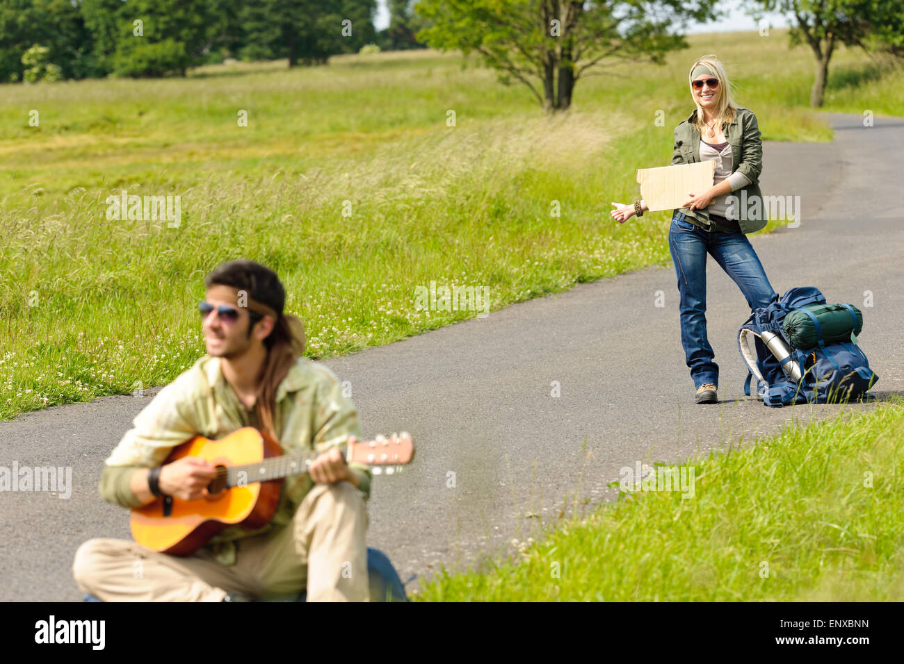 Hitch-hiking young couple backpack asphalt road Stock Photo - Alamy