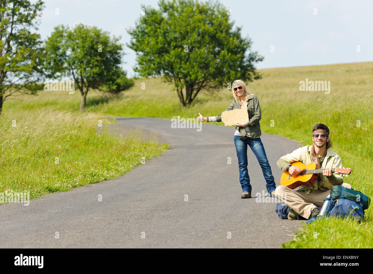 Hitch-hiking young couple backpack asphalt road Stock Photo - Alamy