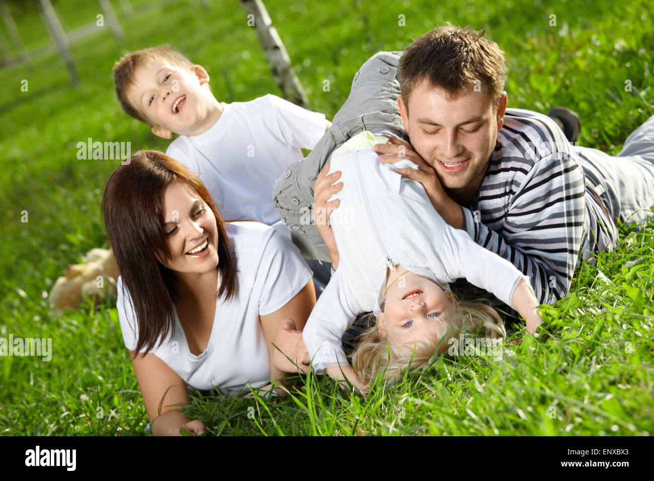 Young family with two small children frolics on a lawn Stock Photo - Alamy