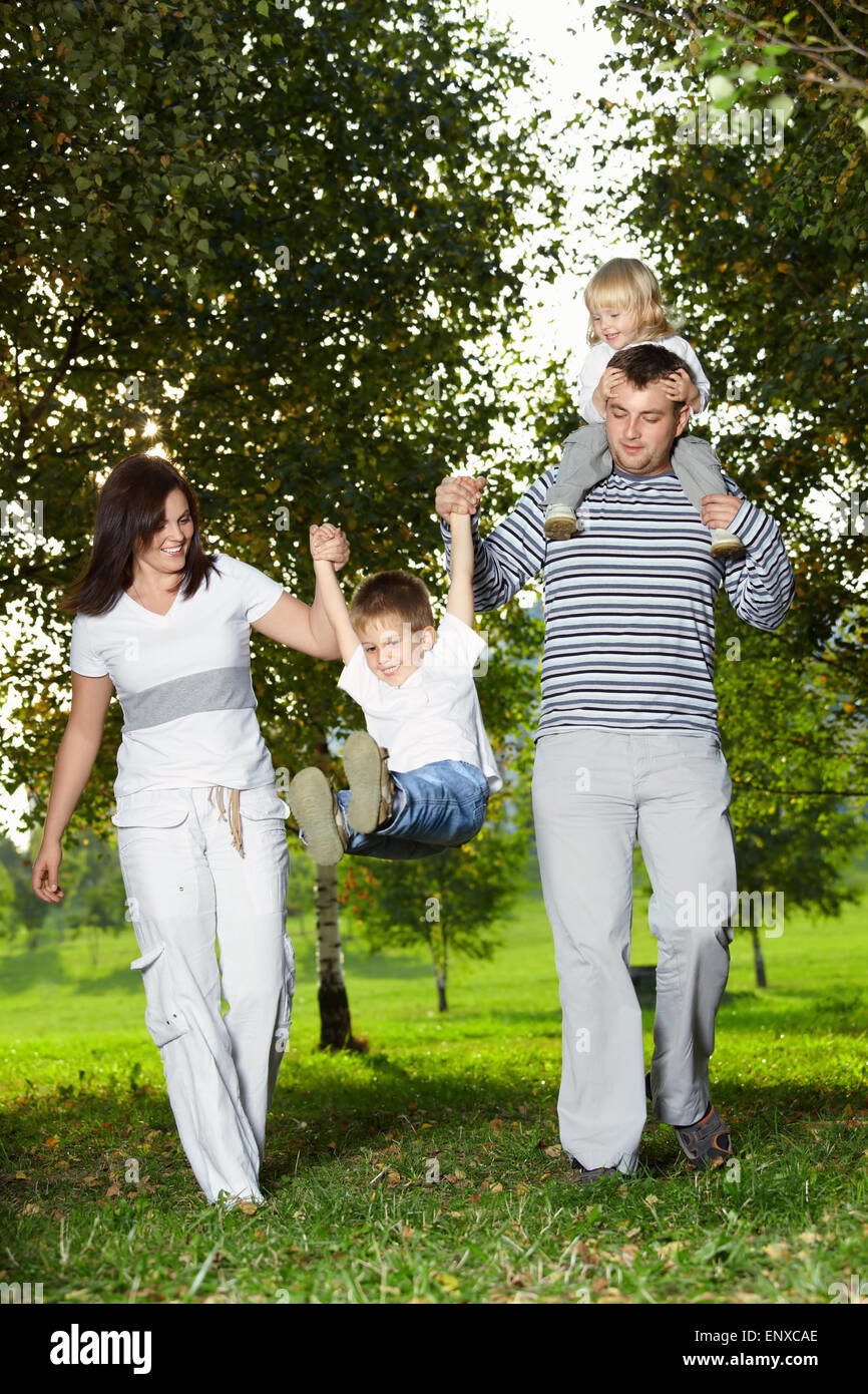 Quick family with small children runs on a lawn Stock Photo - Alamy