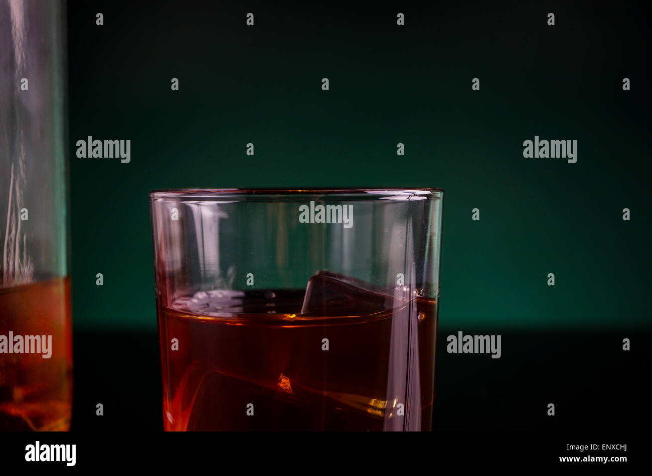 A glass of whisky or rum, with green backlight Stock Photo - Alamy