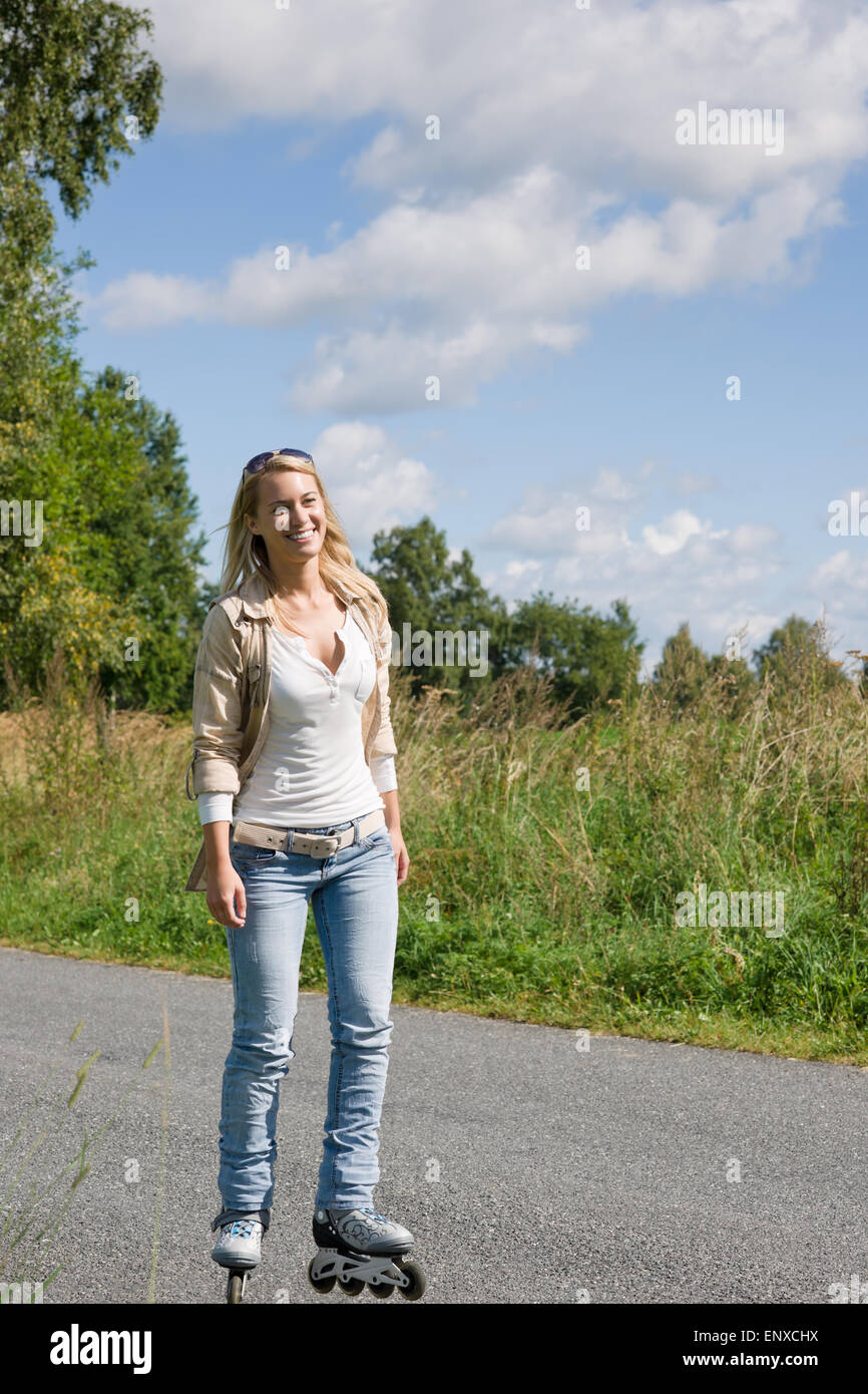 Inline skating young woman on sunny asphalt road Stock Photo - Alamy